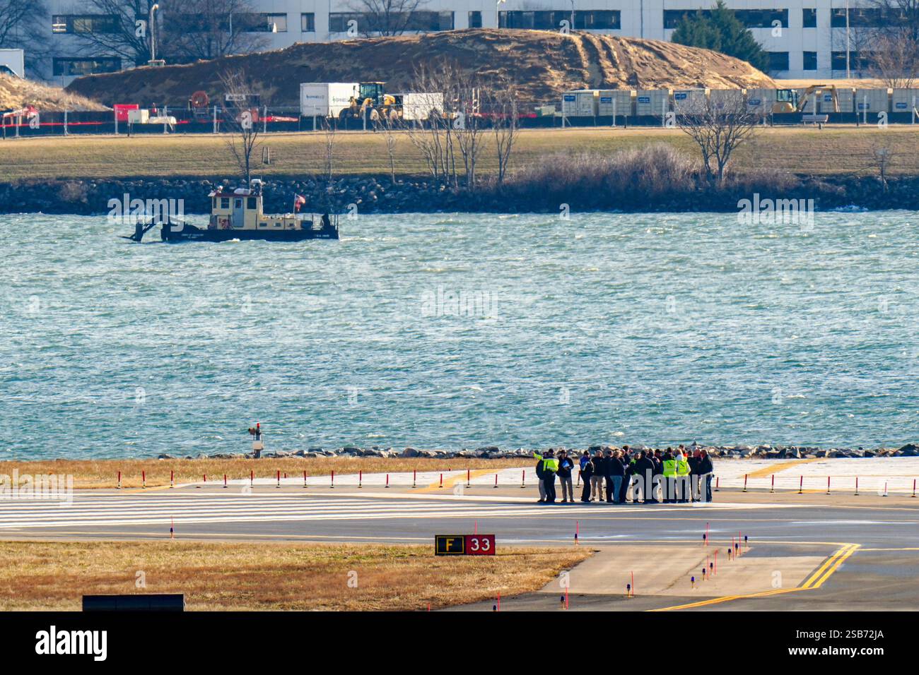Airport Police, NTSB and other officials gather on the approach end of ...