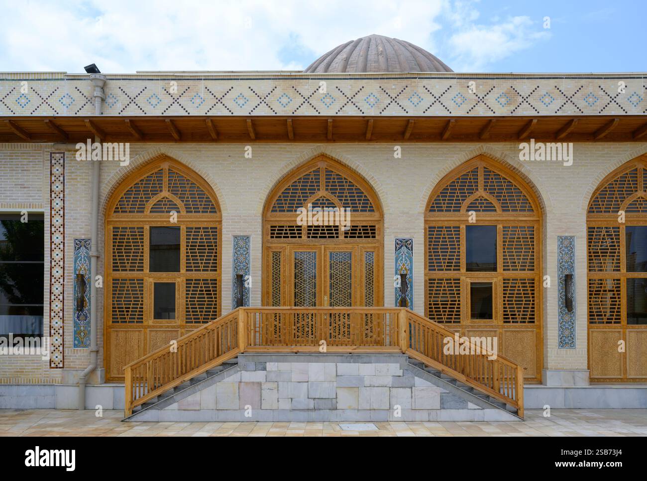 Fragment of buildings with wooden carvings and traditional Uzbek ...
