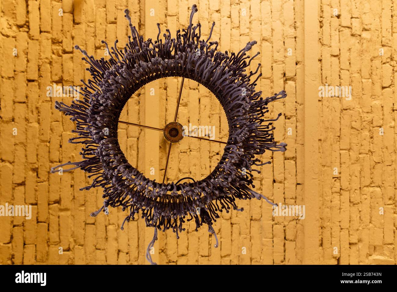 Macrame lampshade with fringes, suspended in front of a warm ...