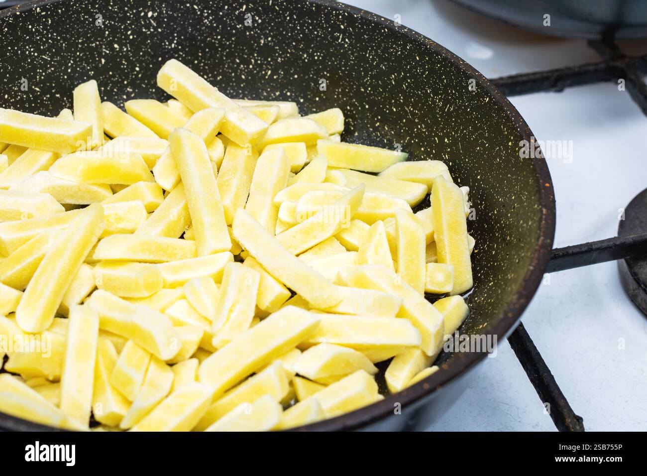 Currently, French fries are in the process of being cooked in a frying ...
