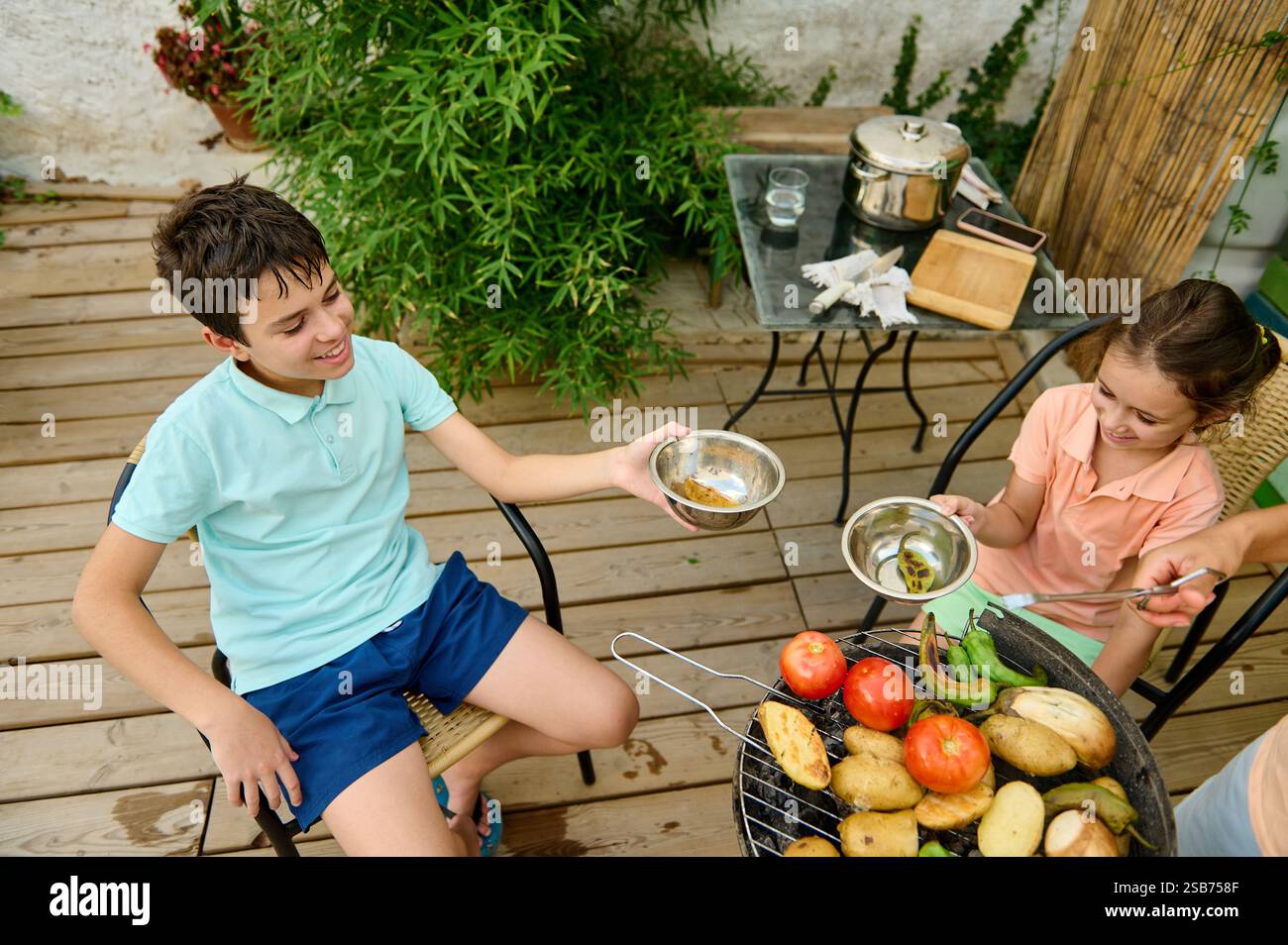 A joyful backyard barbecue with children passing bowls, featuring ...