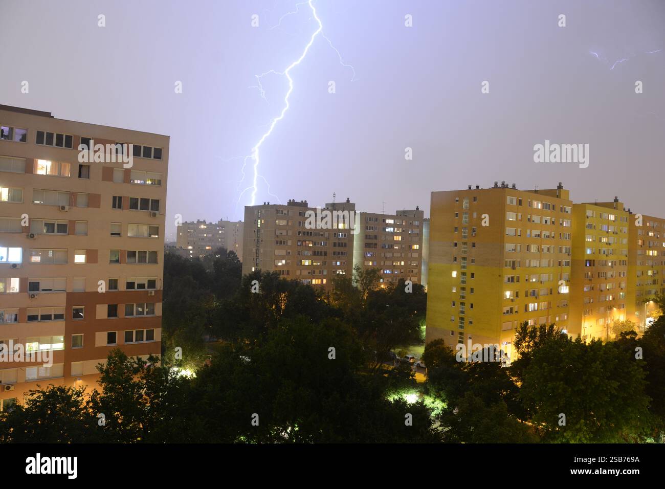 A dramatic view of a Budapest housing estate through a window, with dark black clouds and a ...
