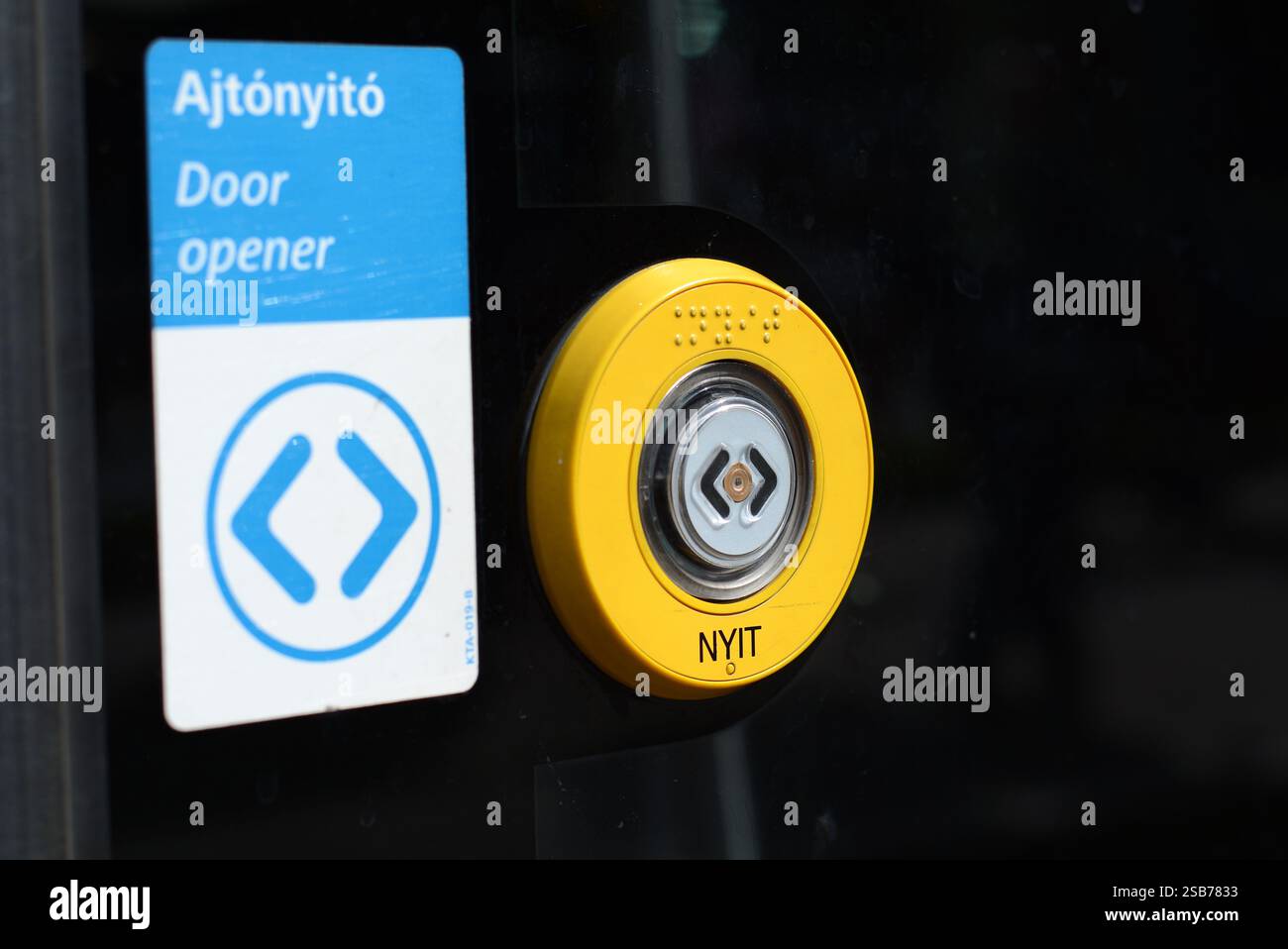 Yellow "open door" button on the outside of a tram, with English and ...