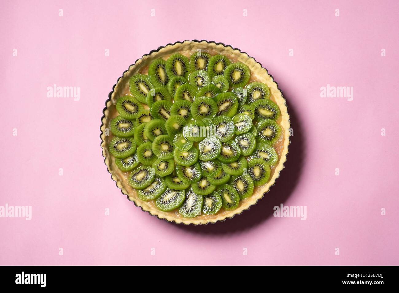 An artistic display of a sweet pie with perfectly arranged kiwi slices ...