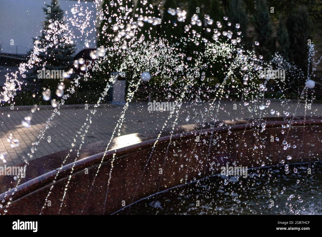 Water streams from a fountain in a city park, creating sparkling ...