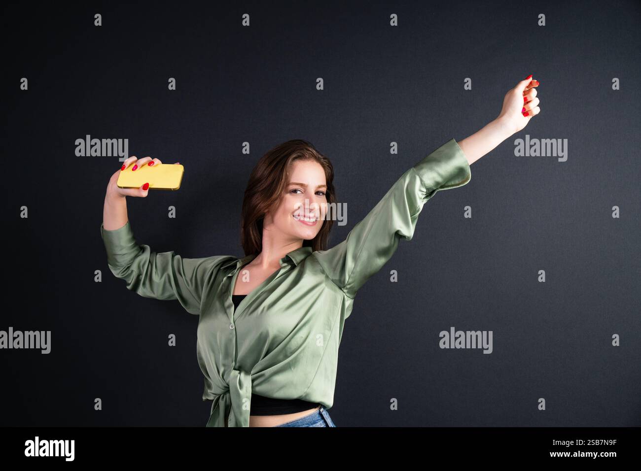 Happy woman dancing against colored background with eyes closed Stock ...