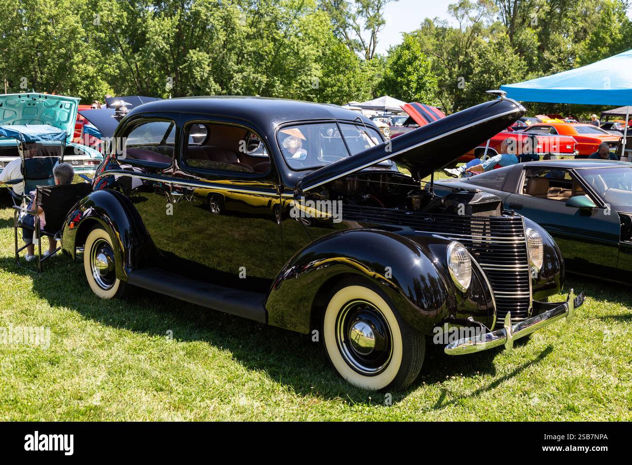 A black 1938 Ford Standard two-door sedan on display at a car show in ...