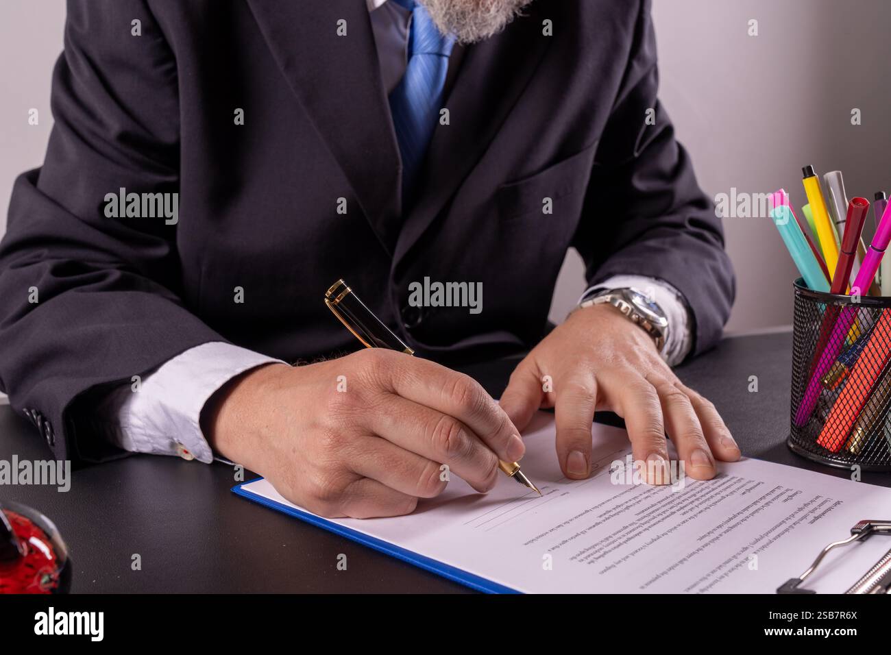 Business professional signing an important contract at office desk ...