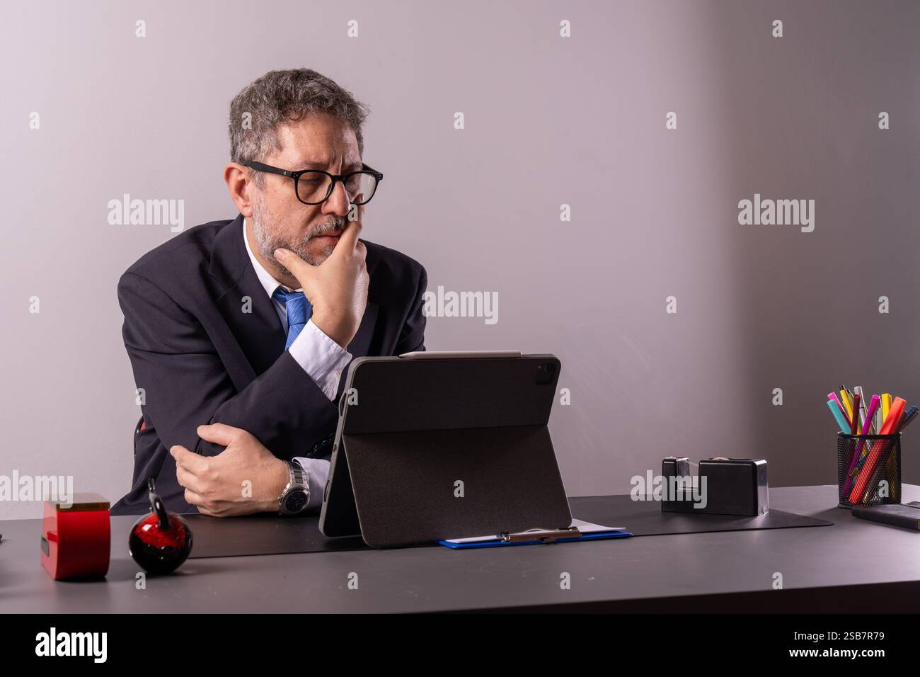 Business professional deep in thought while analyzing a document at the ...
