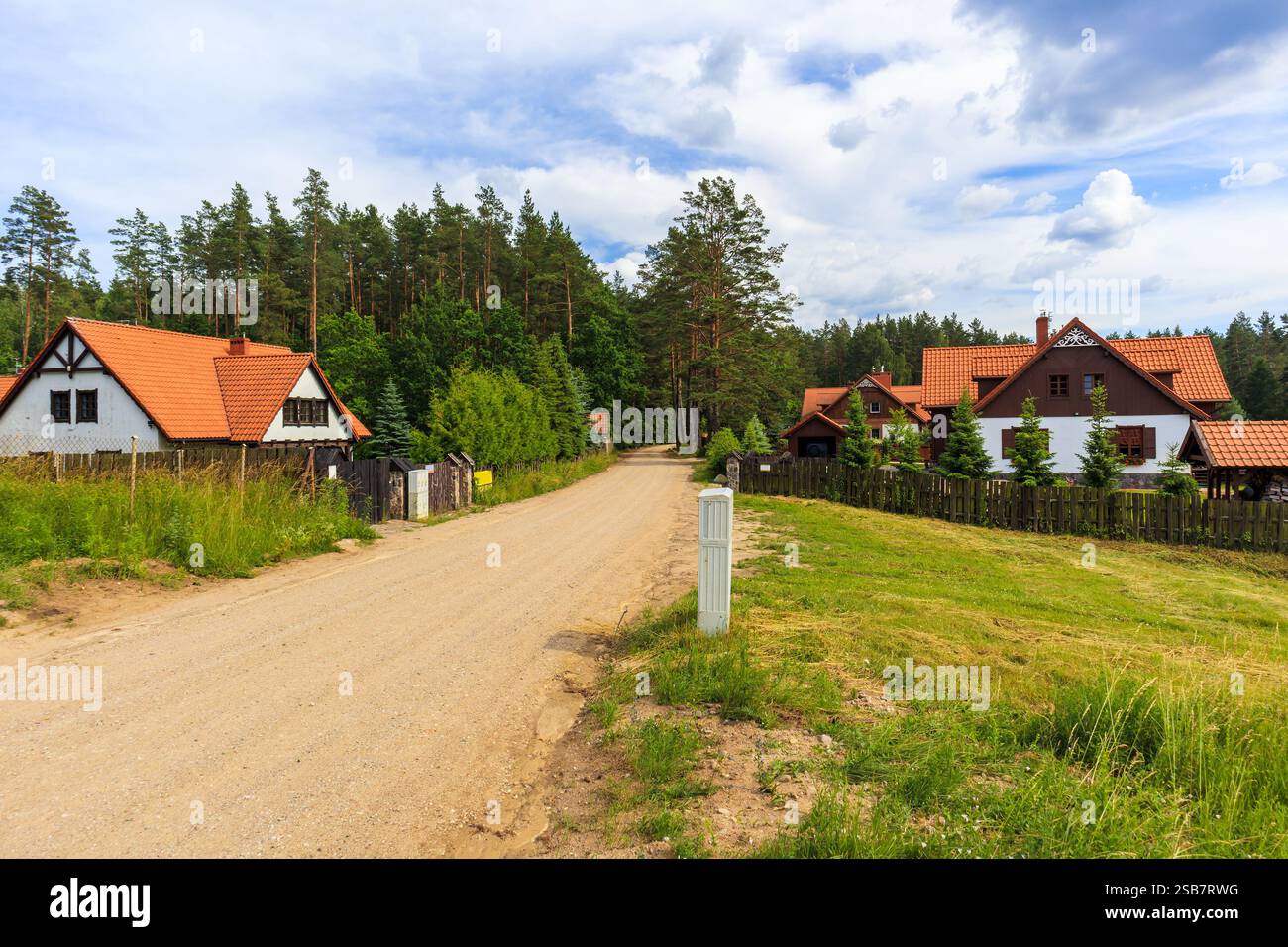 Rural road and traditional style rustic houses in Wygryny village near ...