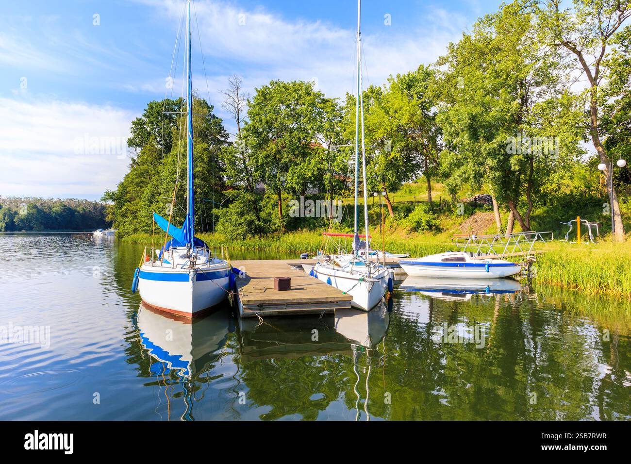 Sailing boats on lake shore in Ruciane-Nida town marina in early ...