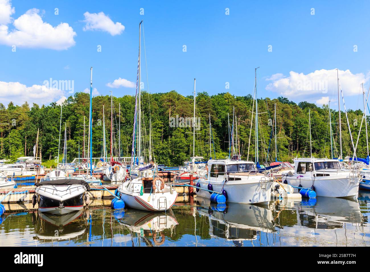 Reflections of sailing boats on lake shore in Ruciane-Nida town marina ...