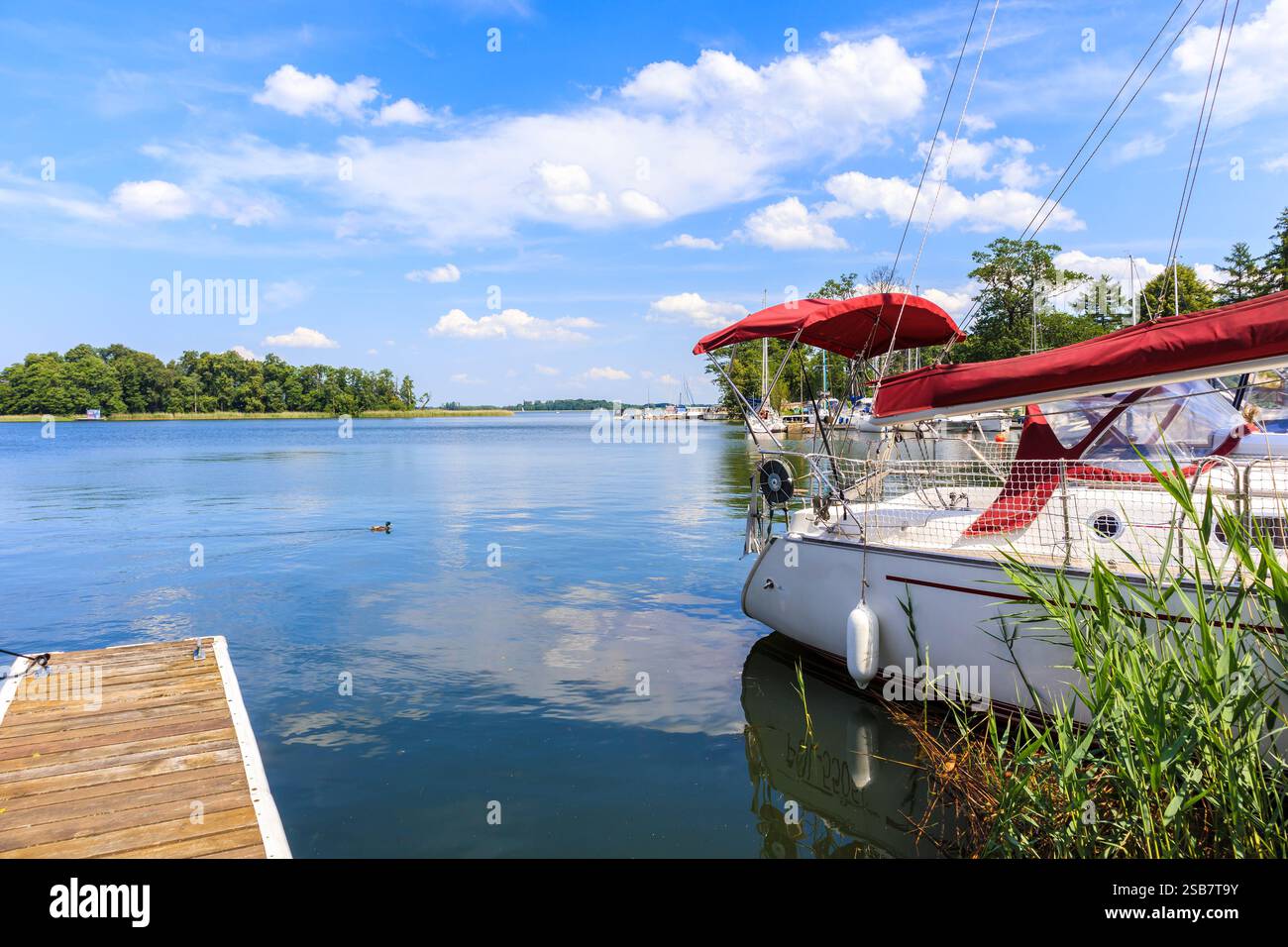 Sailing boat anchoring at shore of Lake Beldany in port Wierzba on ...