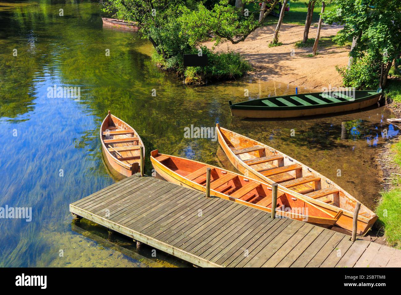 Wooden boats at pier on bank of Krutynia river where tourists do ...