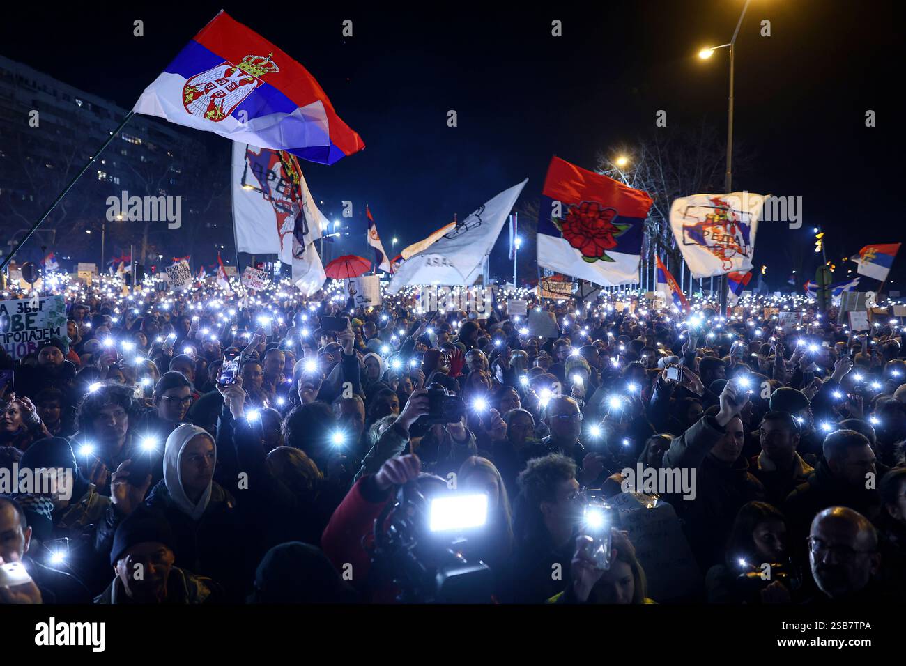 People hold up their mobile phone lights during a protest over the ...
