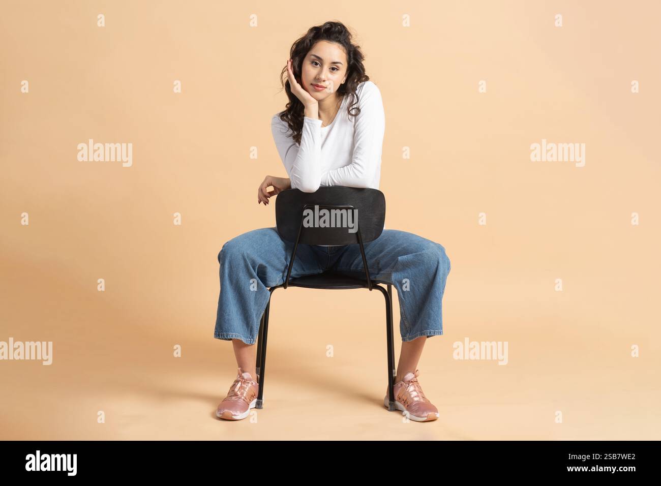 Lifestyles concept. Studio portrait of beautiful young woman sitting on ...