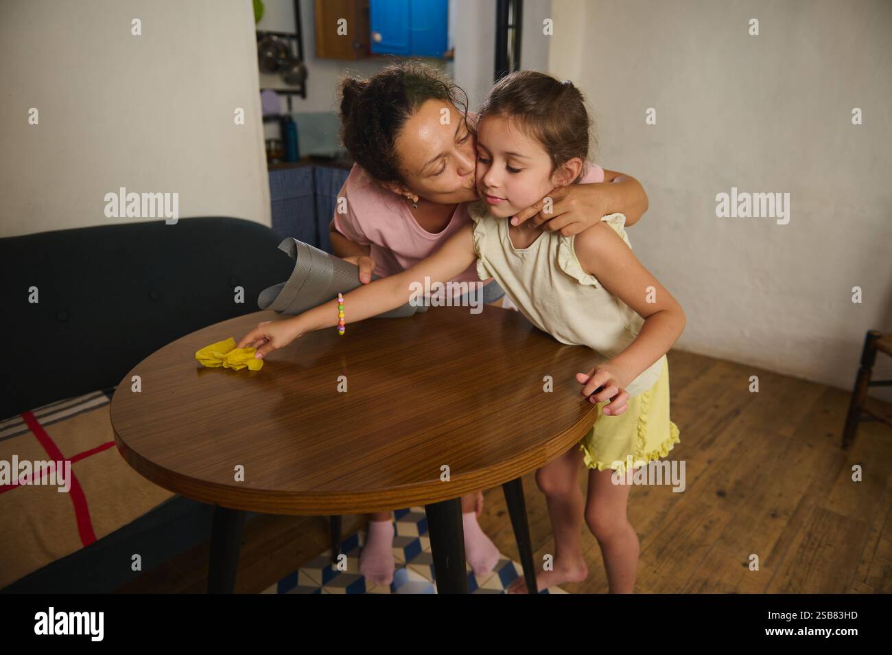 A heartwarming moment of a mother and daughter engaging in household ...