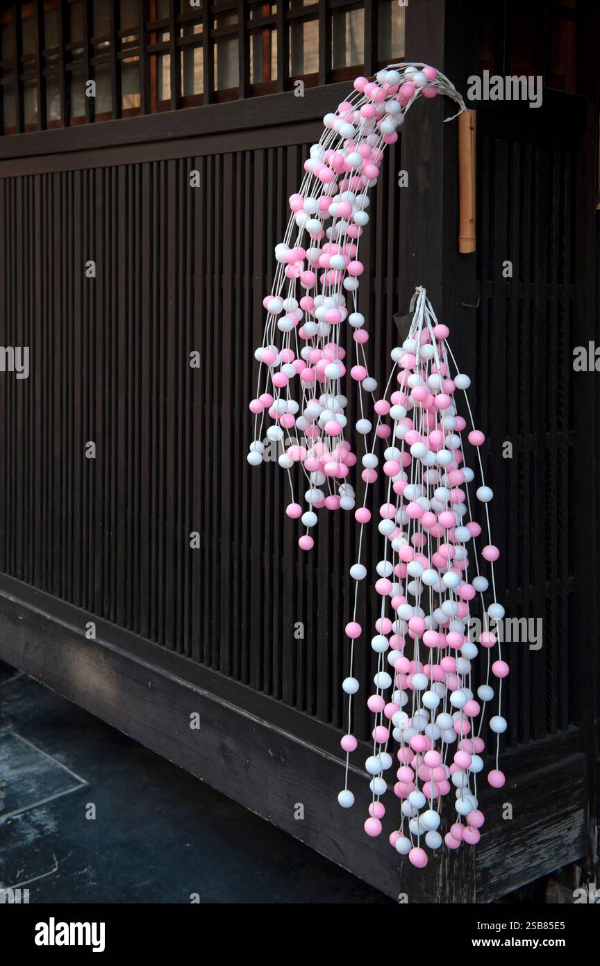 Pink and white plastic ball decoration cascading down on front of a ...