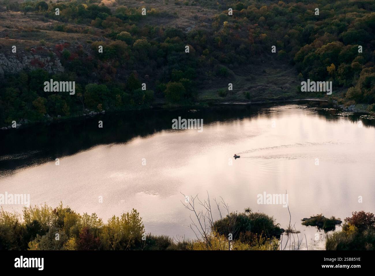 a huge wide river flows among steep banks on the water surface a small ...