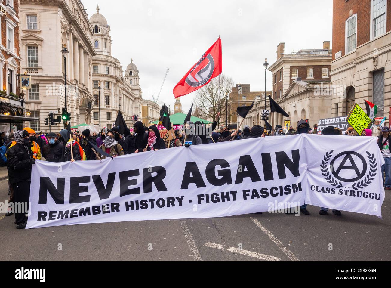 London, UK. 01 FEB, 2025. Members of Antifa hold "Never again" banner ...