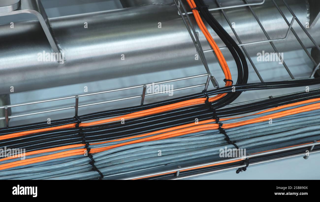 A long metal pipe with many wires hanging out of it. The wires are ...