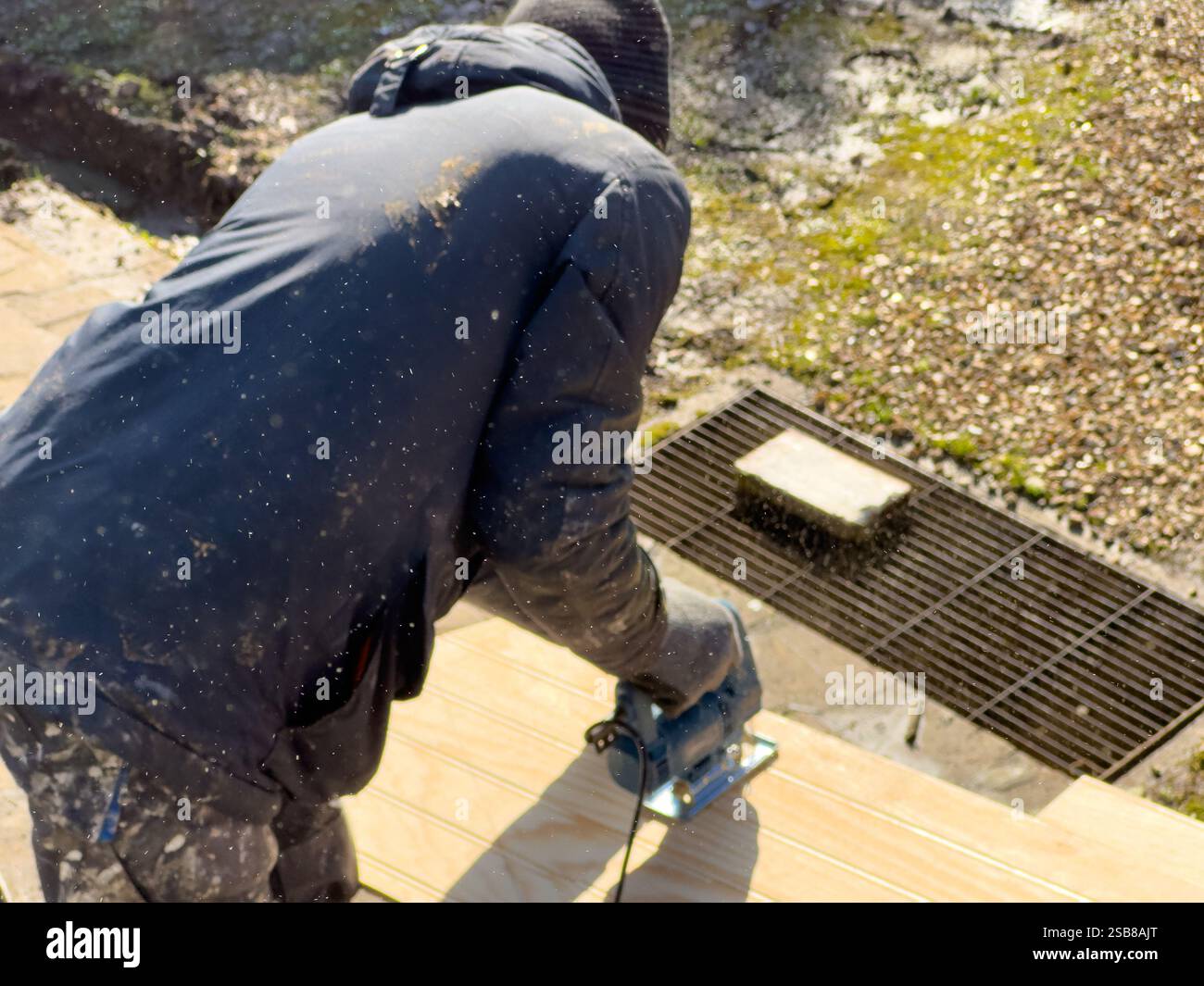 Craftsman shaping wood with precision at a sunny outdoor workspace ...