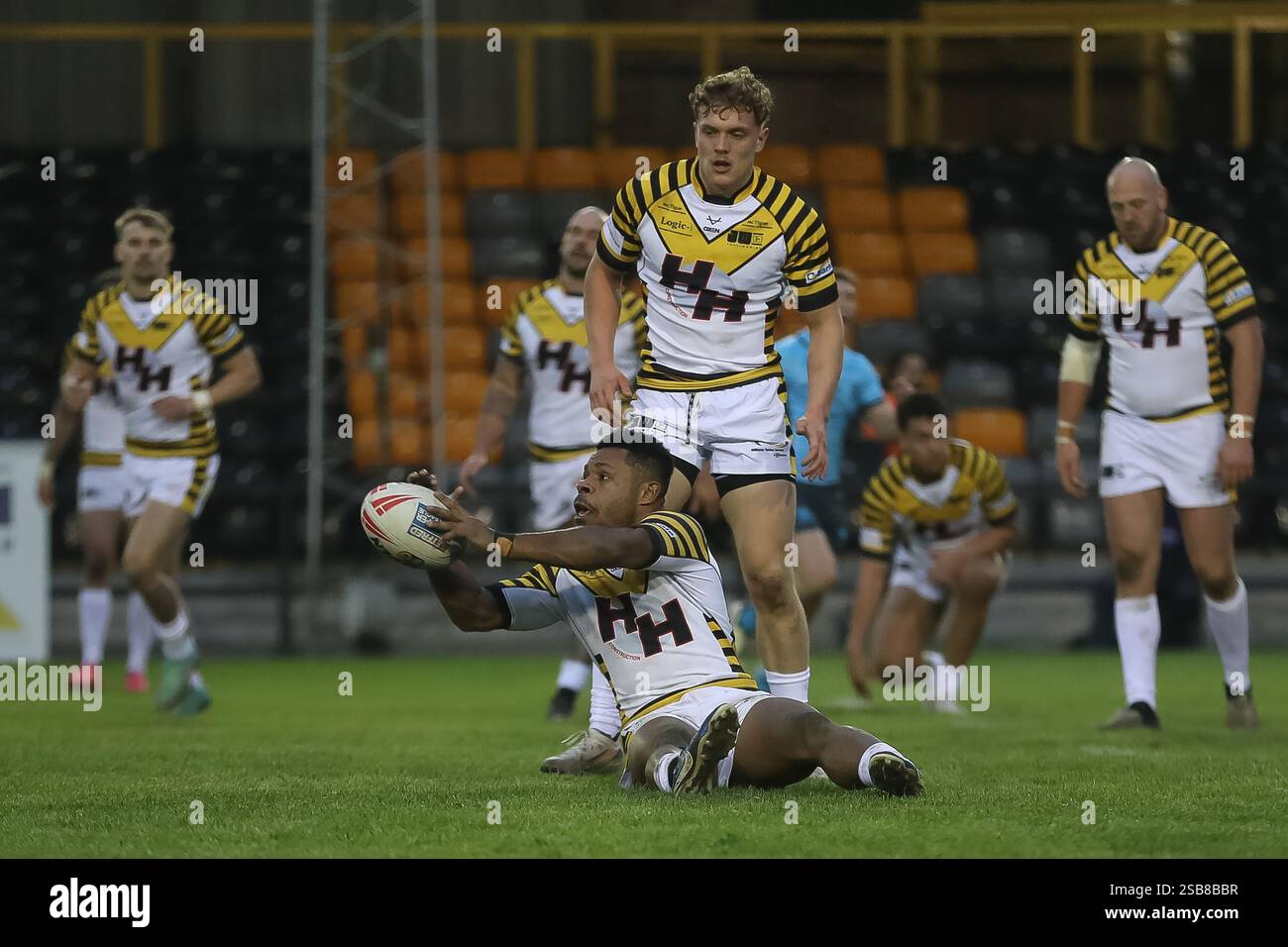 Judah Rimbu of Castleford makes a pass whilst sitting down *** during ...