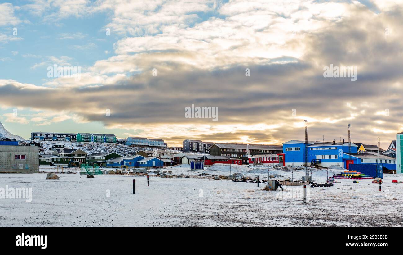 Inuit houses on the hill in Nuuk city covered in snow in a sunset ...