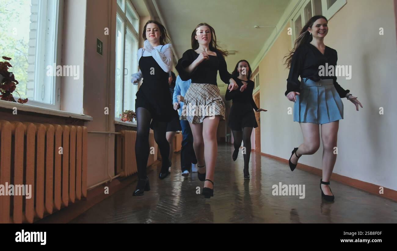Happy students running down school hallway after the bell rings ...