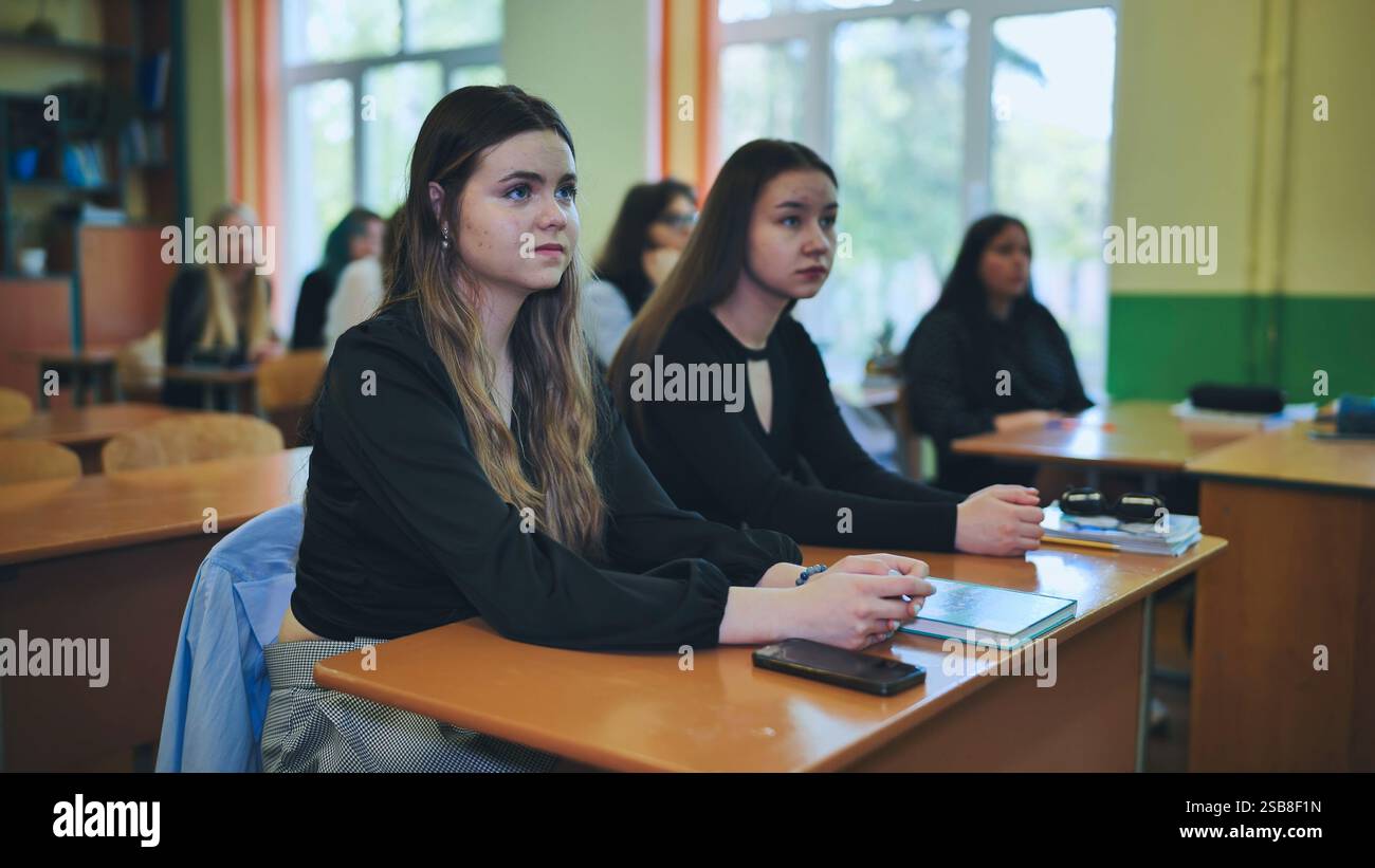 High school students actively engaged in a classroom lesson, listening ...
