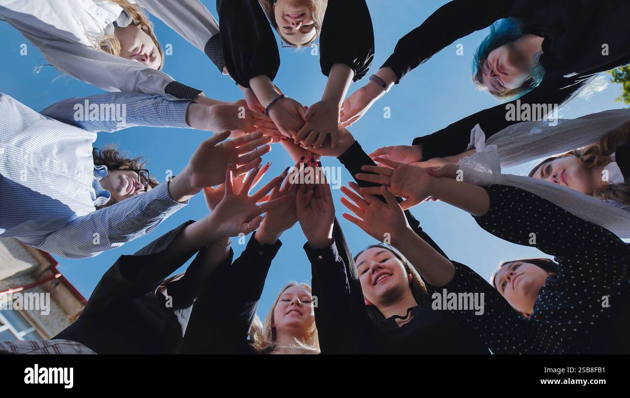 Group of students joining hands together in a circle, celebrating their ...