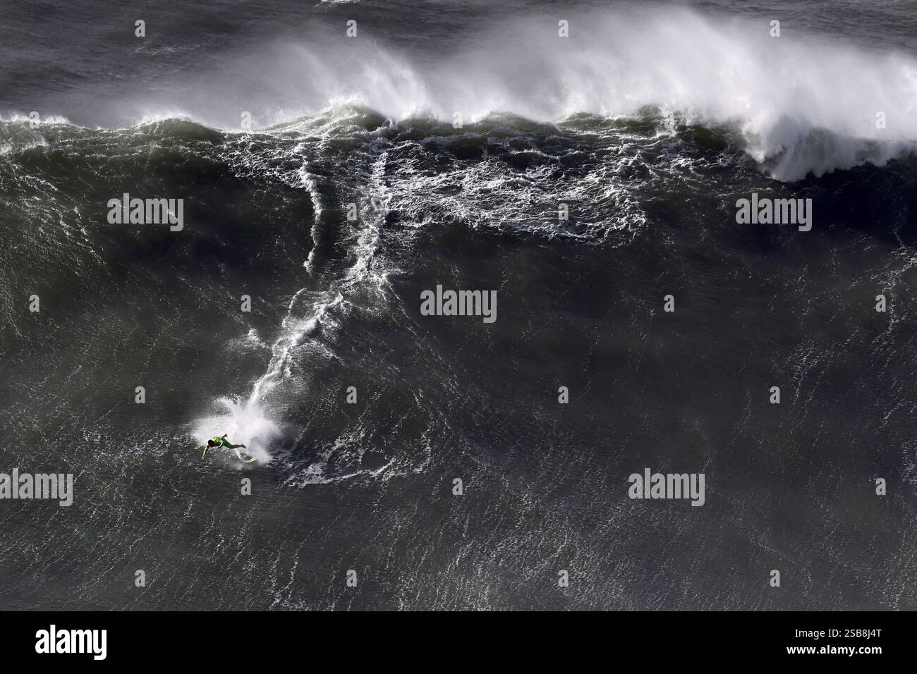 NAZARE, PORTUGAL - JANUARY 28: Surfer riding a big wave during a ...