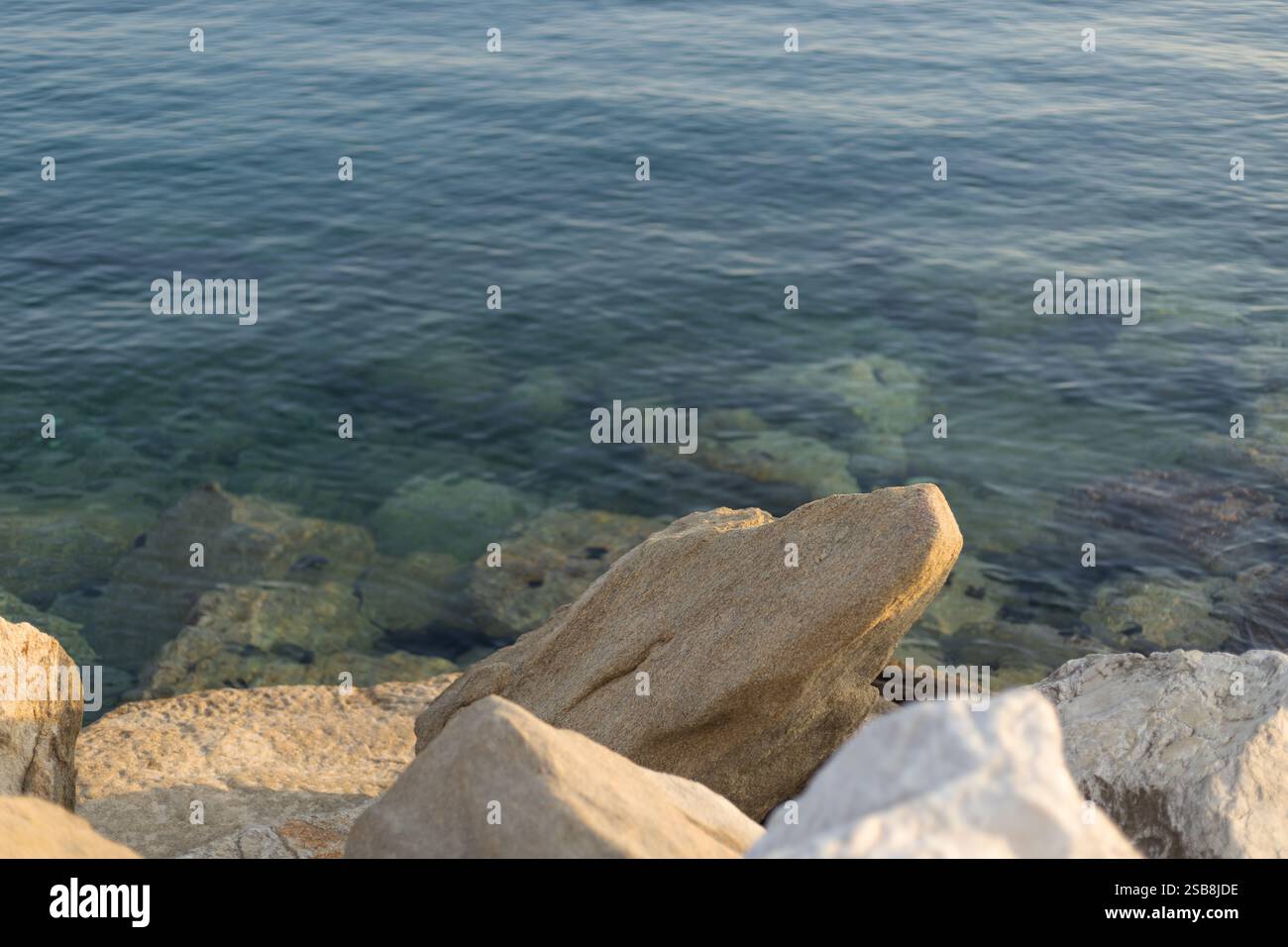 large layers of stones in sea bays with blue water Stock Photo - Alamy