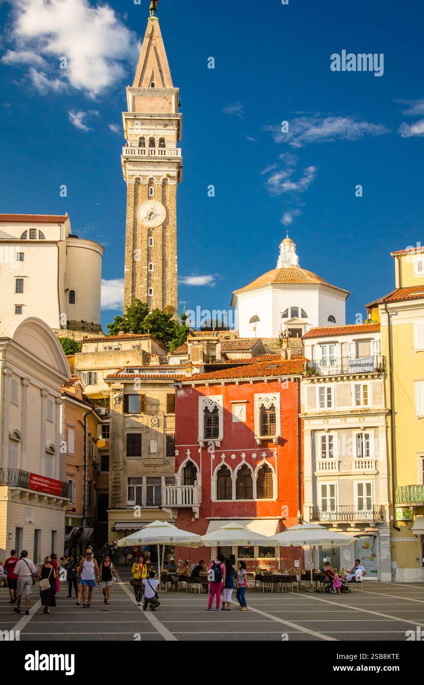 The lively square features a mix of colorful buildings and a tall clock ...