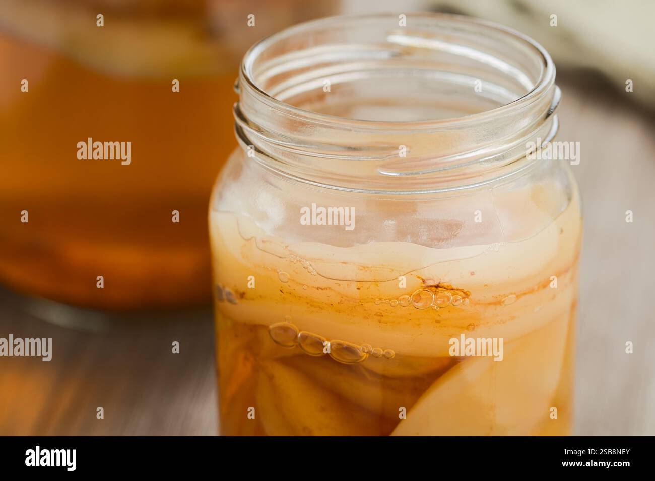 Homemade black tea kombucha or tea mushroom in glass jar with lots of ...