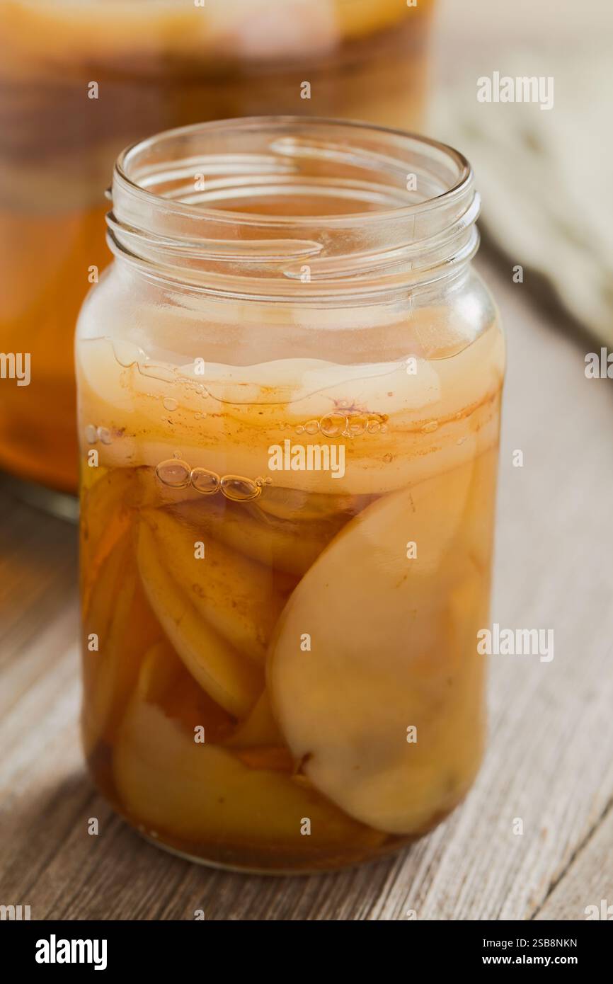 Homemade black tea kombucha or tea mushroom in glass jar with lots of ...