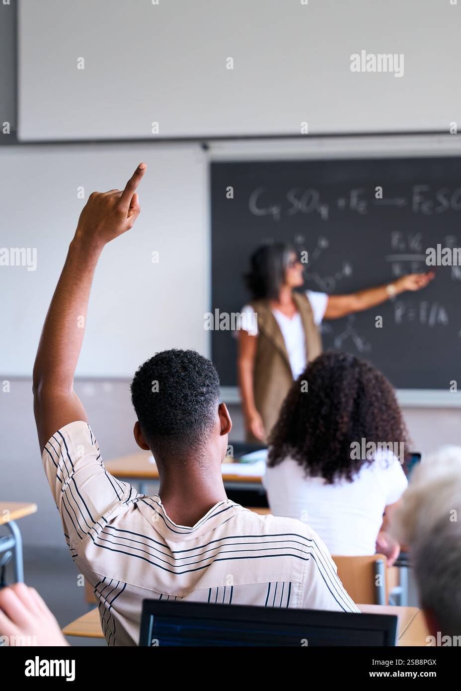 Young group of gen z students attending class at high school. Young black student boy asking ...