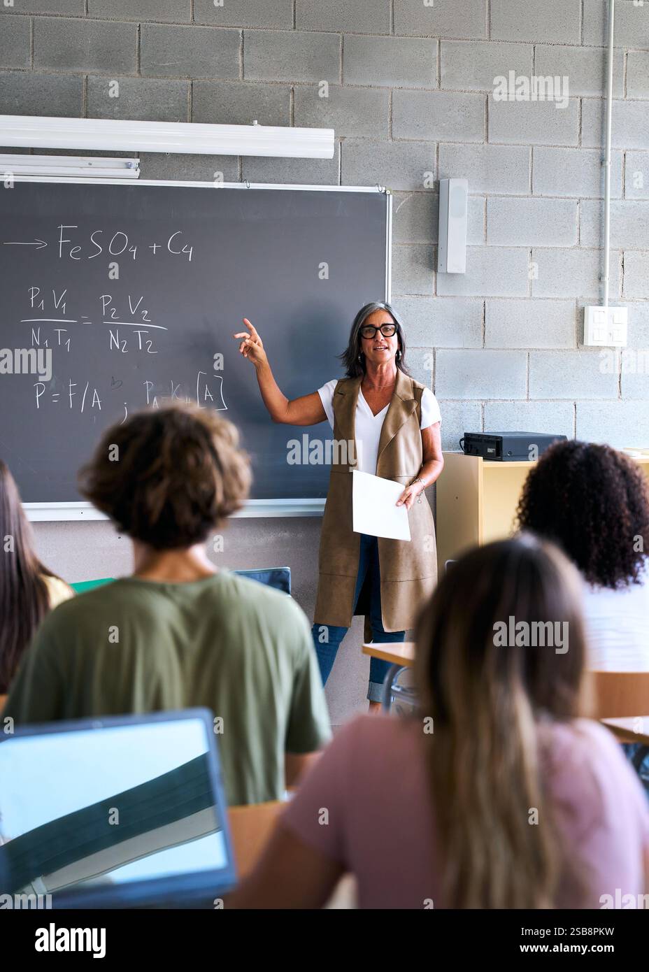View from behind a group of multiracial students taking notes in a ...