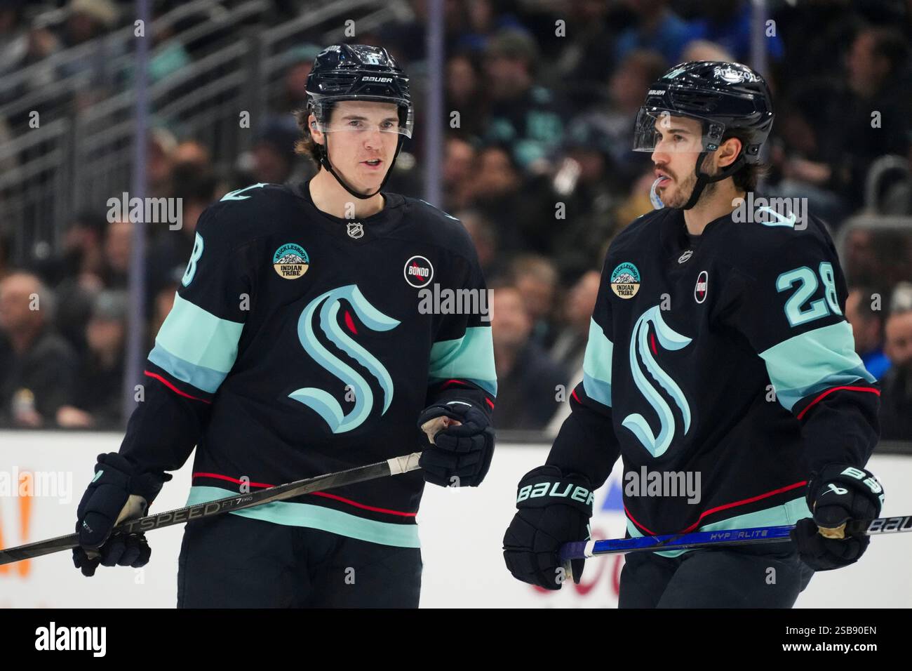 Seattle Kraken defenseman Cale Fleury, left, talks with defenseman ...