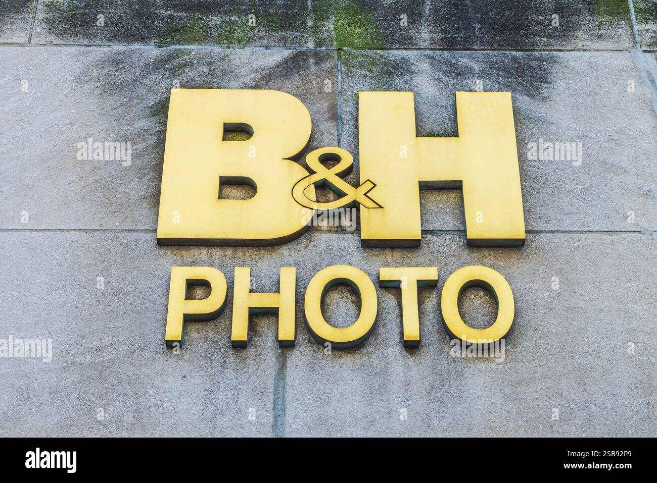Golden B&H Photo sign mounted on textured concrete wall store. New York ...