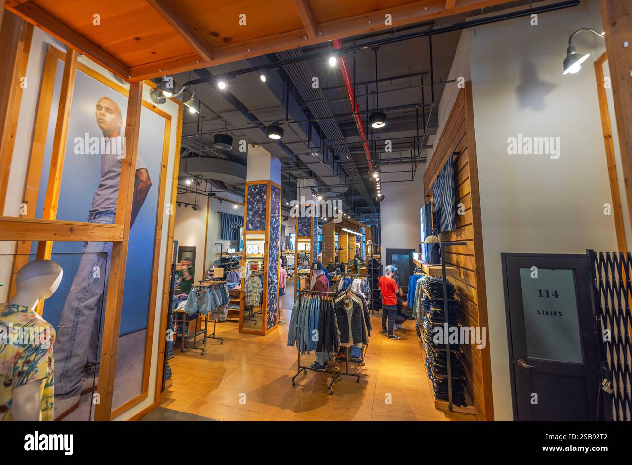 Modern Levi’s store interior with hanging clothes, promotional signs ...