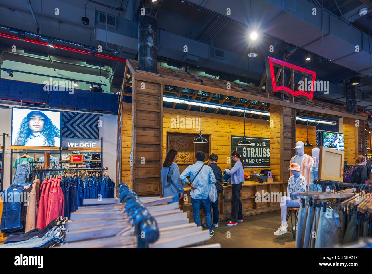 Customers standing at checkout counter in Levi’s store, making purchase ...