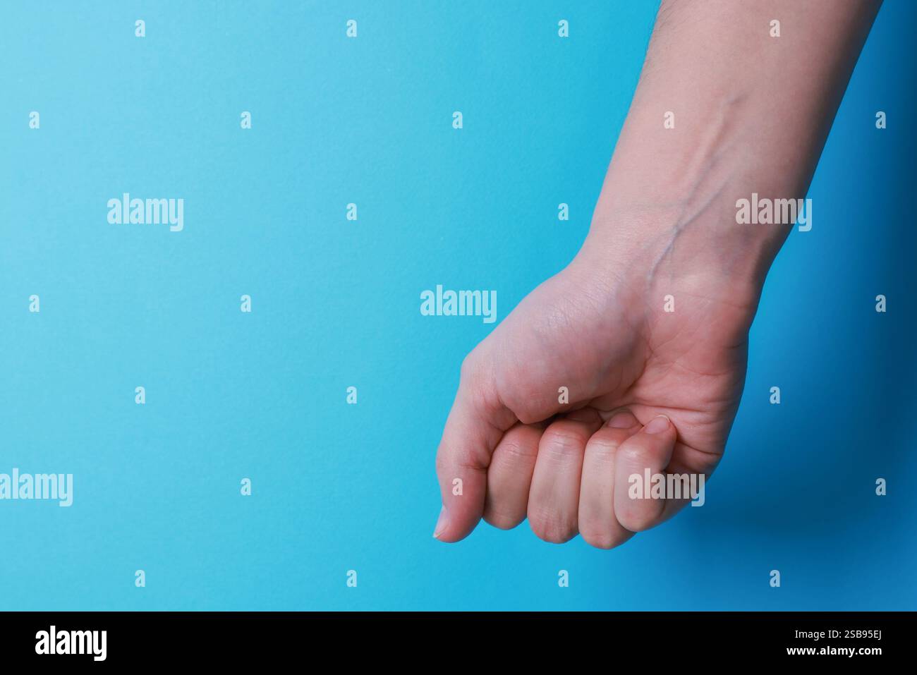 Woman with visible hand veins on light blue background, closeup. Space ...
