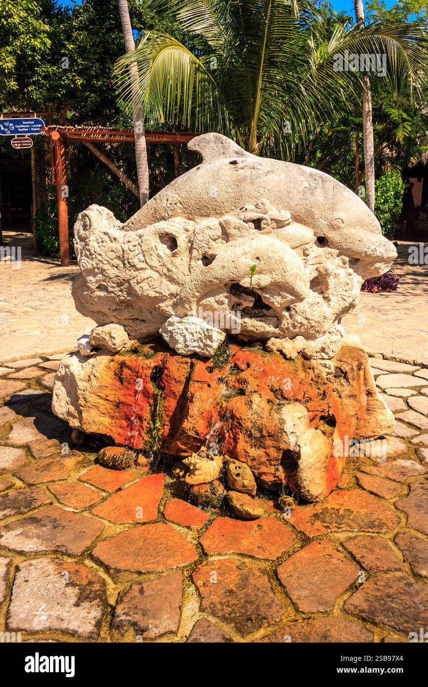 A sculpture of a dolphin and a dolphin is on a rock. The sculpture is ...