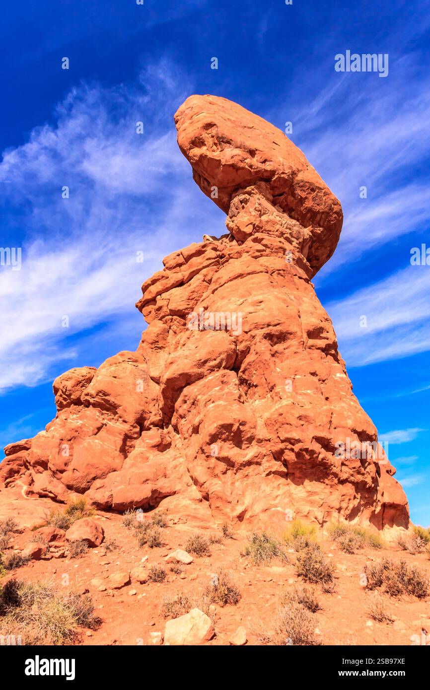 A large rock formation with a pointy top. The sky is blue and there are ...