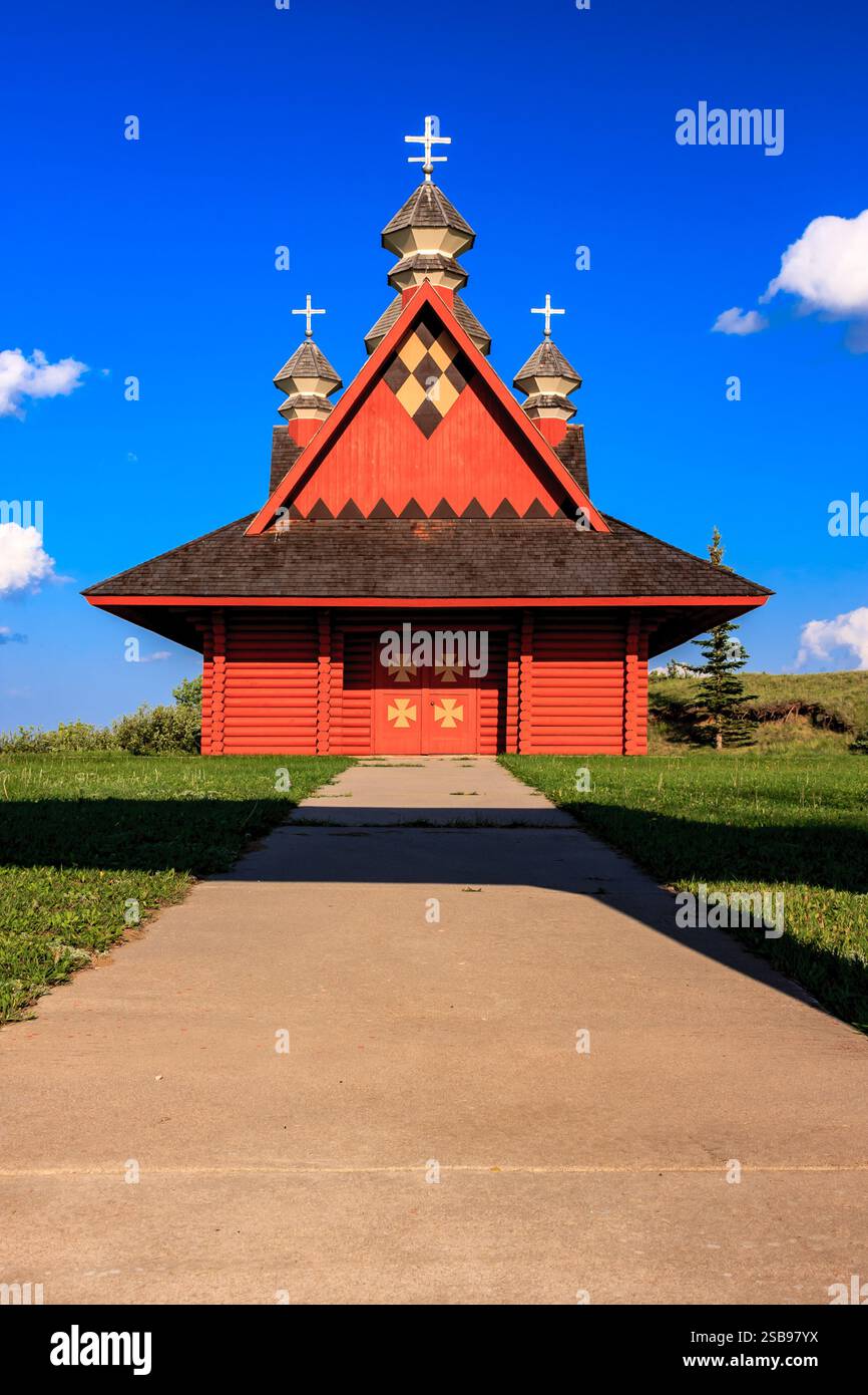 A red church with a blue sky in the background. The church is small and ...