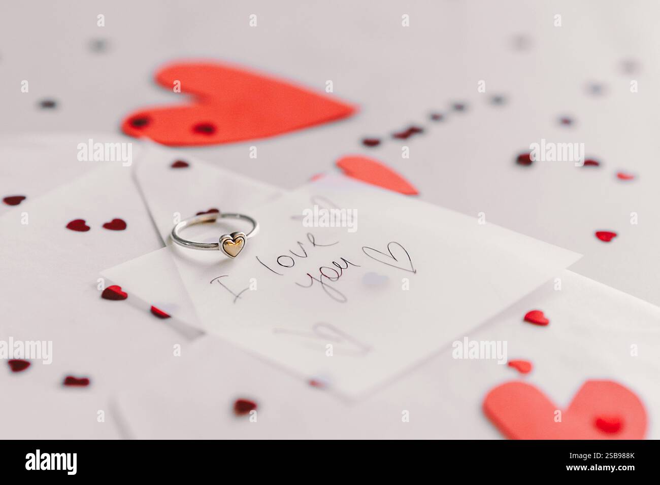 Heartfelt proposal on a handwritten note with a ring on a red paper ...