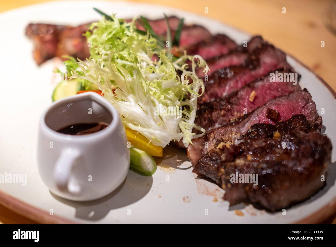 Medium rare wagyu meat served on plate with sauce and vegetable Stock ...