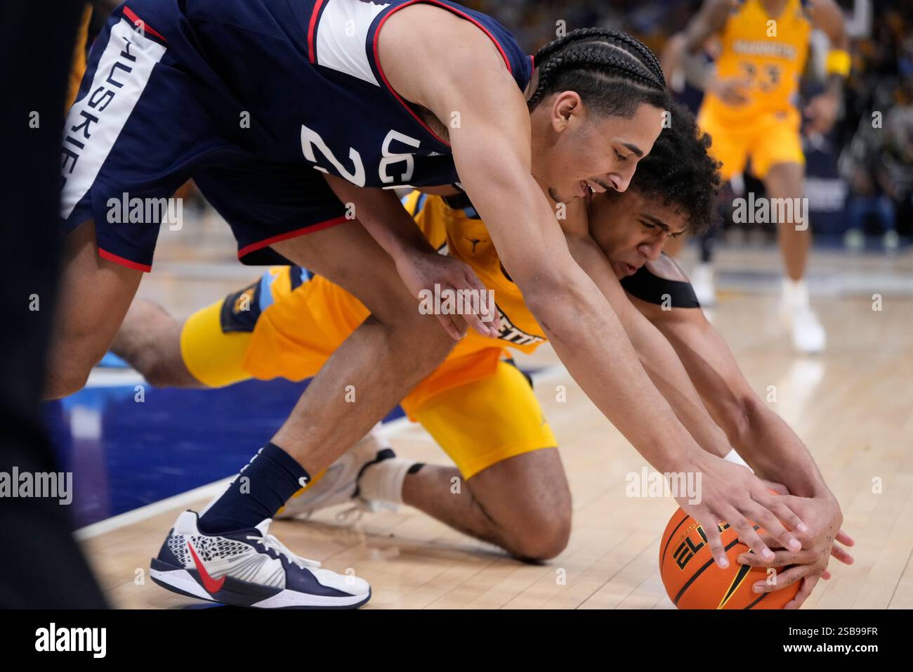 Marquette's Stevie Mitchell and UConn's Jayden Ross go after a loose ...
