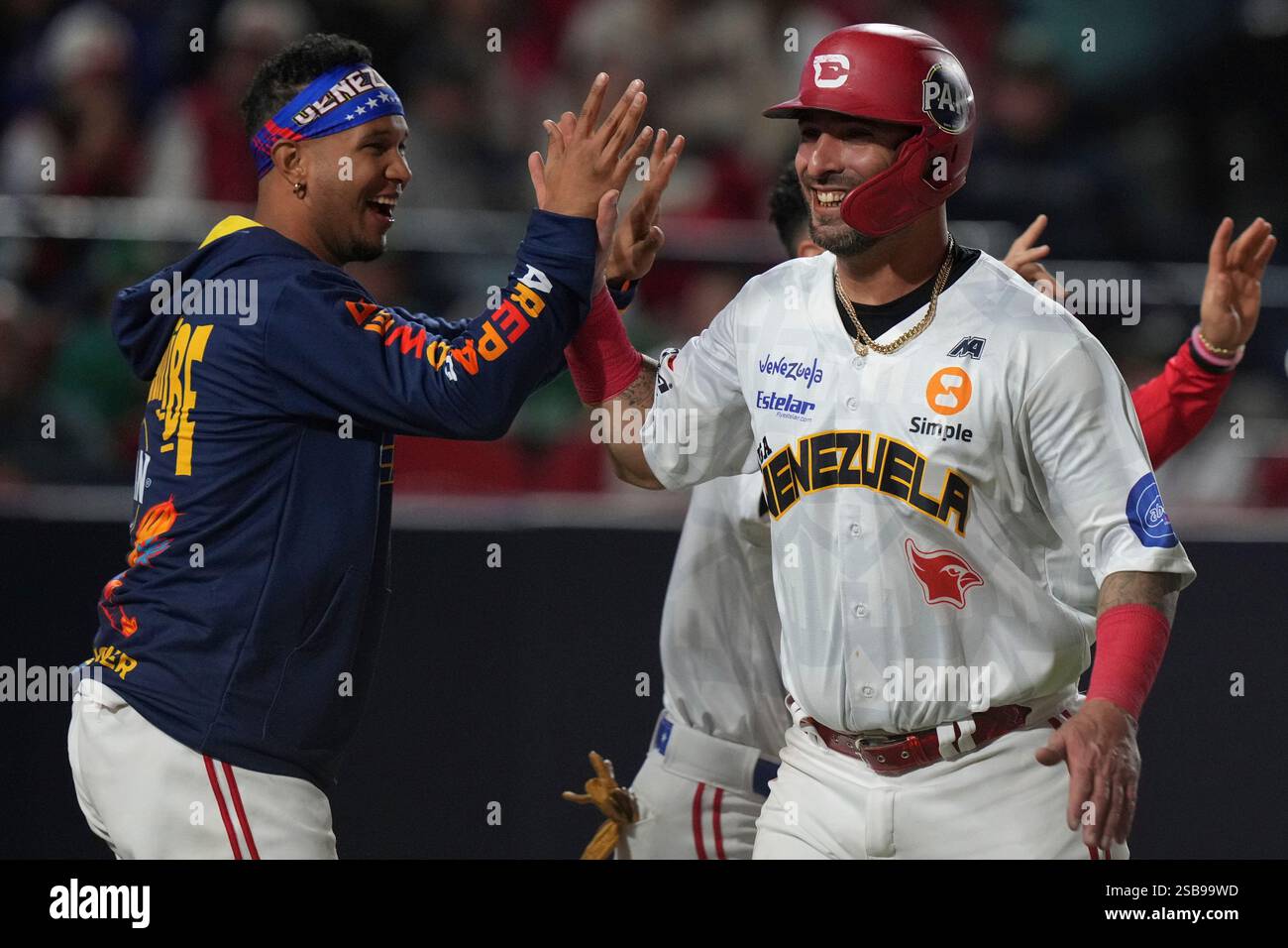 Venezuela's Rangel Ravelo, right, celebrates after scoring a run ...